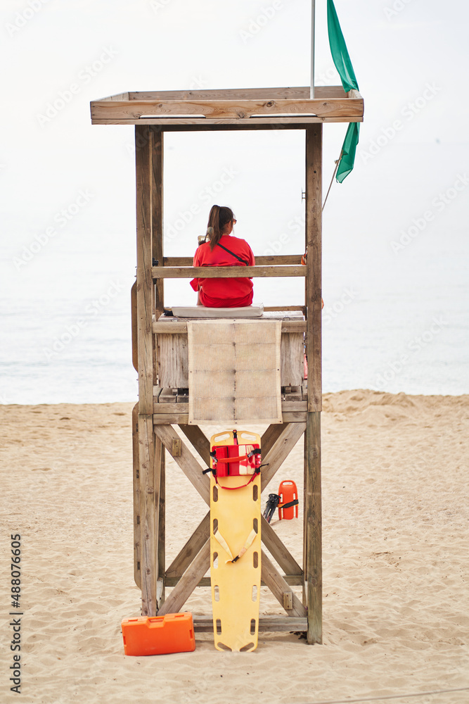 Baywatch sitting on watchtower in beach Stock Photo | Adobe Stock