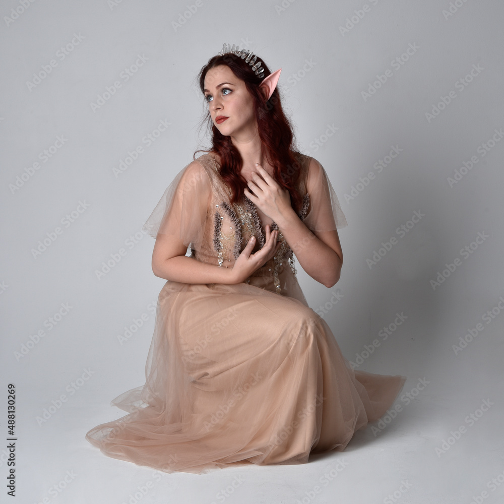 Full length portrait of pretty female model with red hair wearing ...