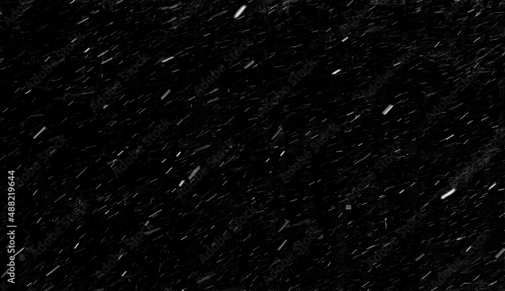 Real snowfall on a black background. Falling snow on a long exposure ...