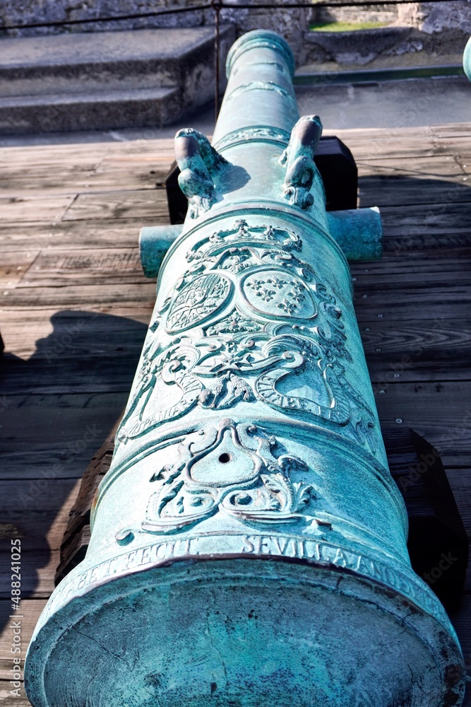 Ornate royal coat of arms on a Spanish cannon at Castillo de San Marcos ...