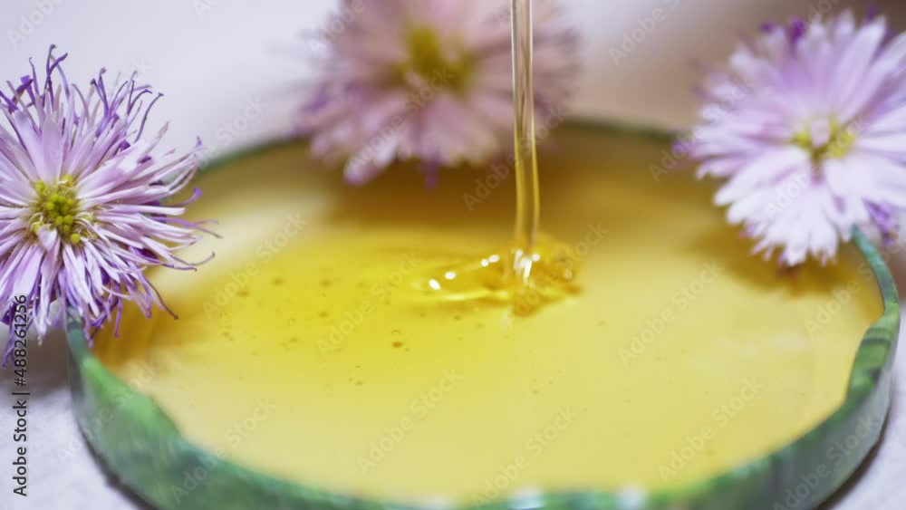 Transparent Natural Honey Flows in a Thin Stream into a Lid, a Bowl ...