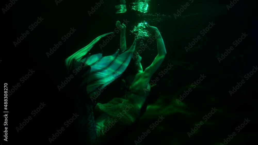 underwater mystery of ocean, enigmatic water-nymph is floating in dark ...