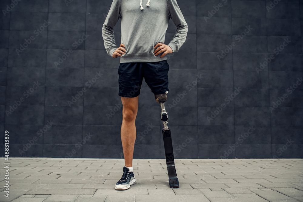 A proud handicapped sportsman with artificial leg standing outdoors ...