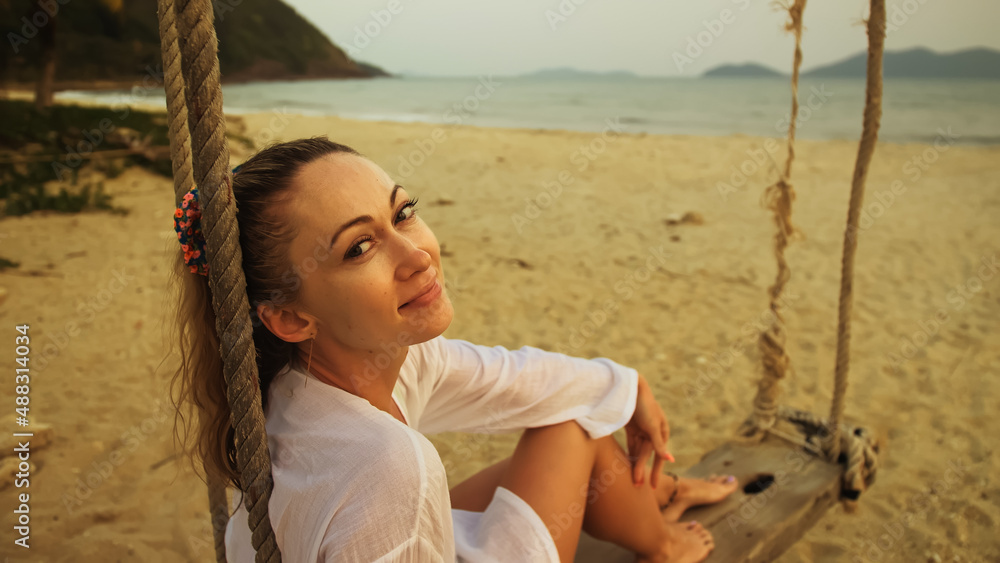Portrait close up woman on the swing on tropical beach. Girl in white ...