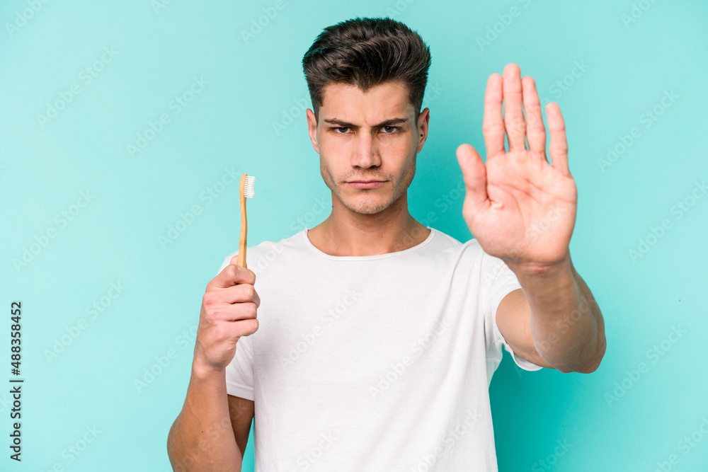 Young caucasian man brushing teeth isolated on white background ...