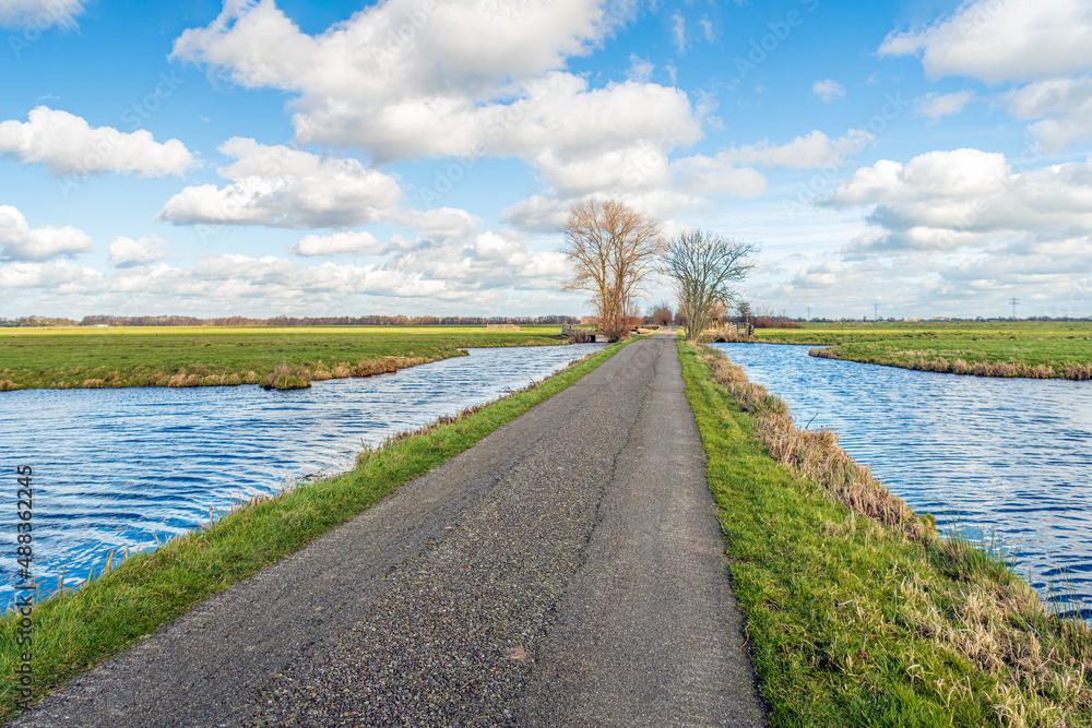 Narrow country road in a Dutch polder with ditches. The photo was taken ...