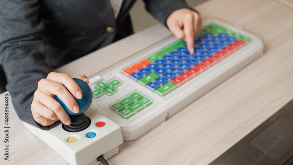 Woman with cerebral palsy works on a specialized computer mouse. Stock ...