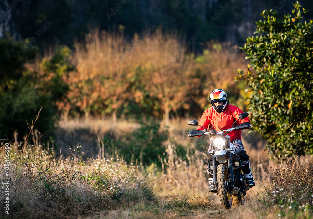 Man riding his scrambler type motorcycle on rugged terrain in Thailand ...
