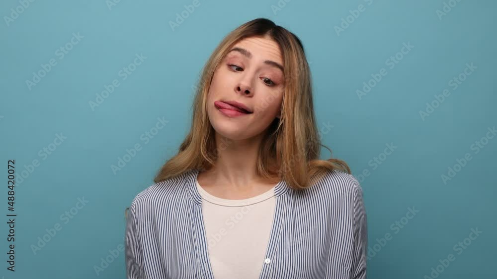 Funny young woman crossing eyes and showing tongue out, playing fool ...