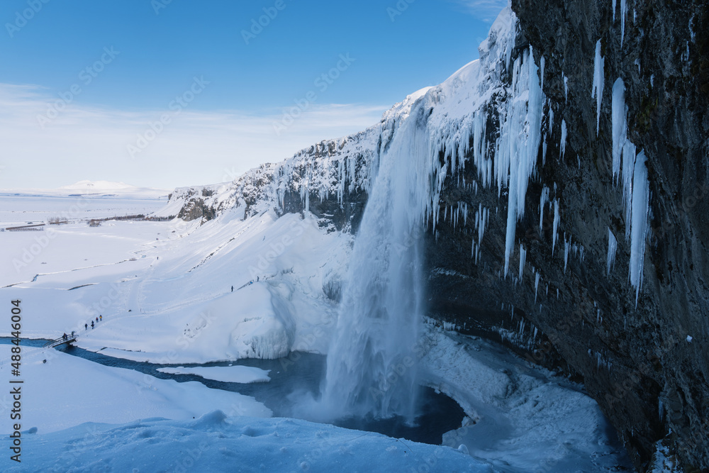 Seljalandsfoss waterfall in winter. Icicles around waterfall and snow ...