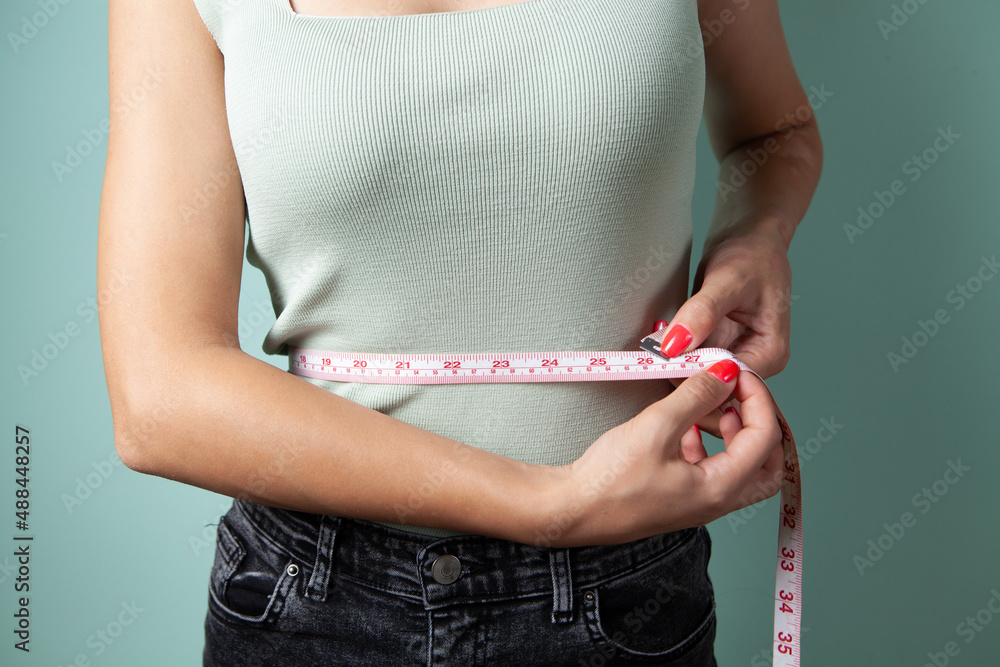 young girl measures belly with a measuring tape Stock Photo | Adobe Stock