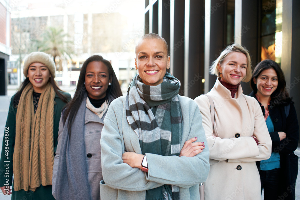 Cheerful portrait of a group of female business looking at the camera ...