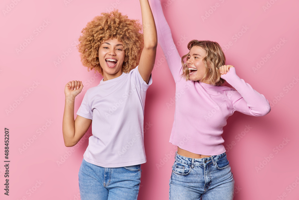 Two friendly girls have fun dance carefree shake arms chill together ...