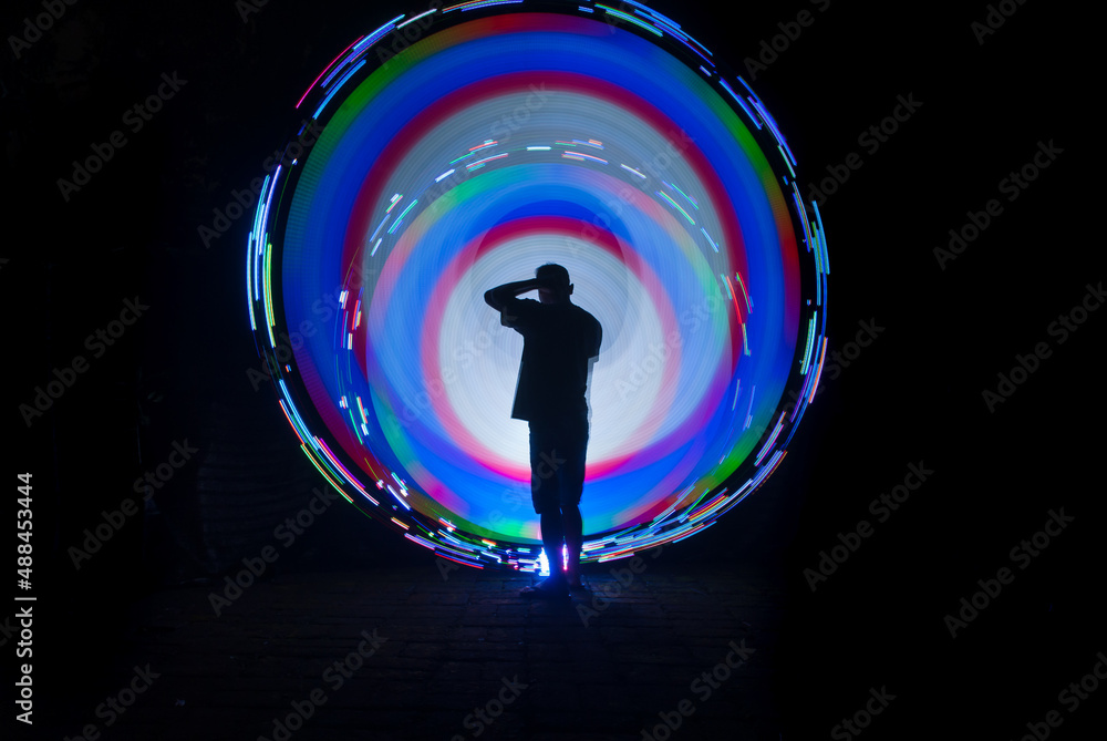 One person standing alone against beautiful color circle LED light ...