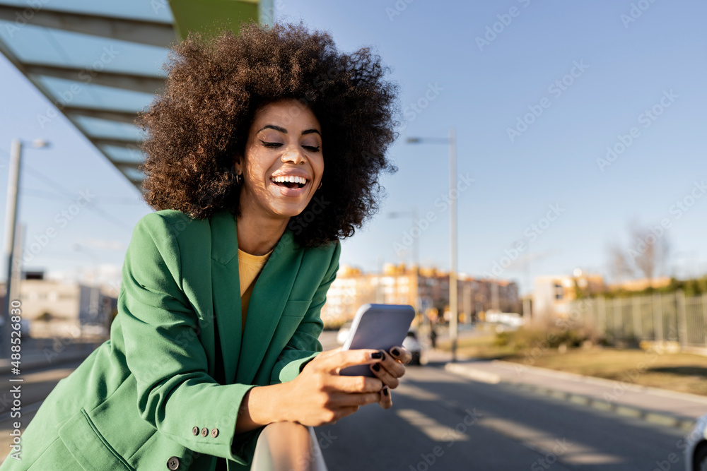 Cheerful commuter using smart phone leaning on railing Stock Photo ...