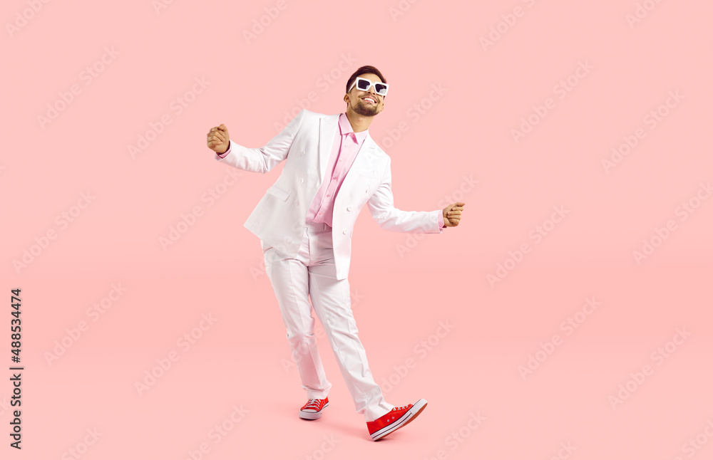 Happy funny guy in white suit dancing isolated on pastel pink ...