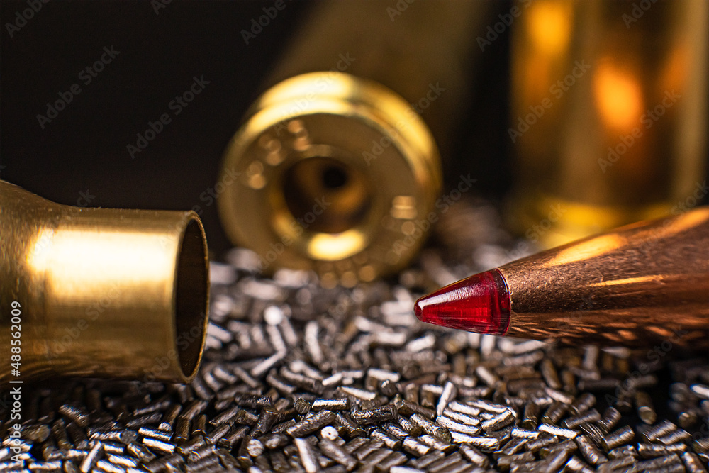 Macro photo of a bullet with a ballistic tip and cartridge cases on a ...