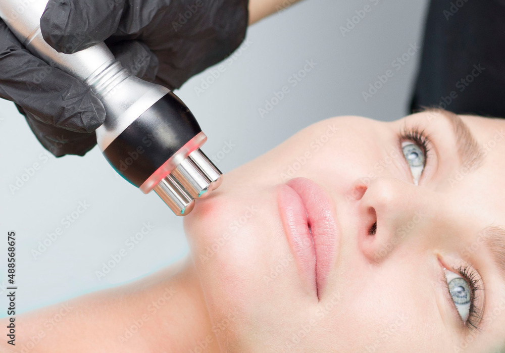 Foto de A young woman is lying on the RF-lifting procedure for face ...