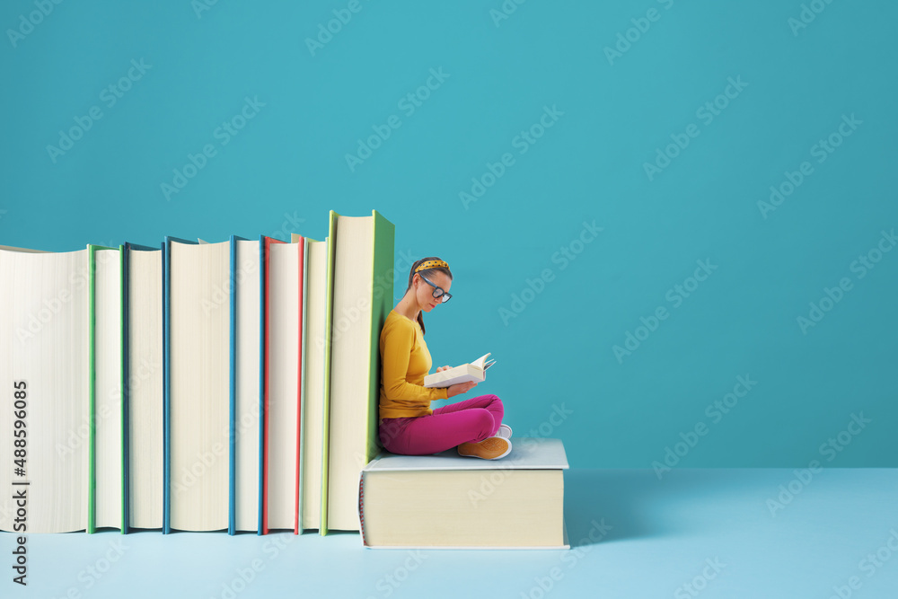 Tiny woman reading books and learning Stock Photo | Adobe Stock