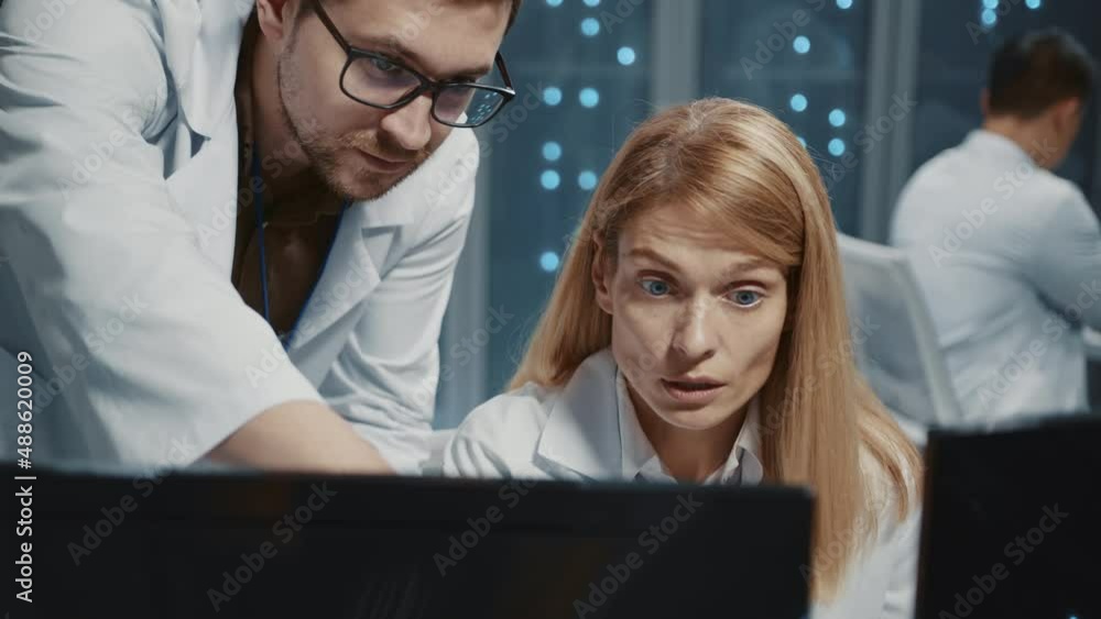 Cooperative team of IT workers wearing laboratory coats conducting ...