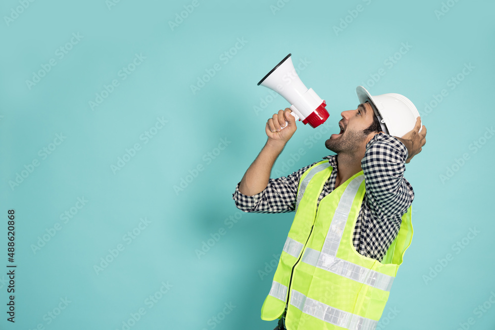 Young professional heavy industry engineer holding megaphone isolated ...