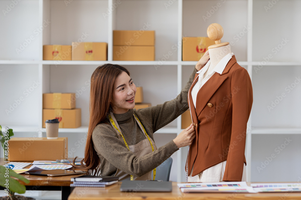 A beautiful Asian woman who owns a clothing brand, she is using a tape ...