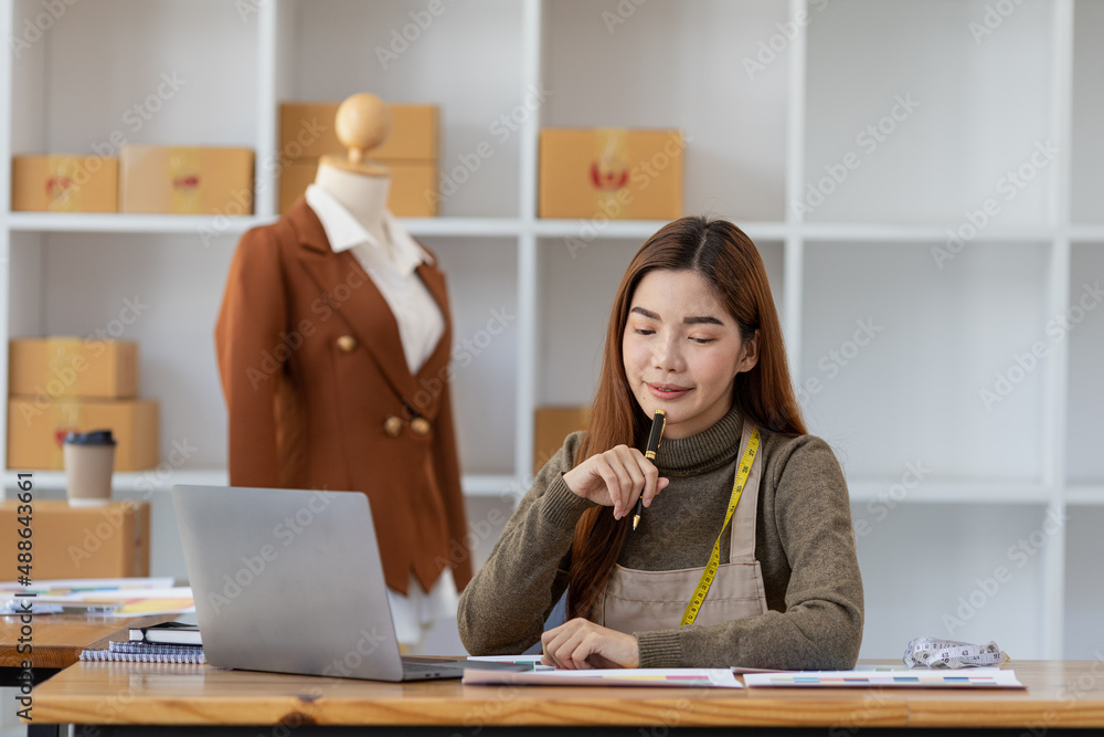 A beautiful Asian woman who owns a clothing brand, she is designing ...