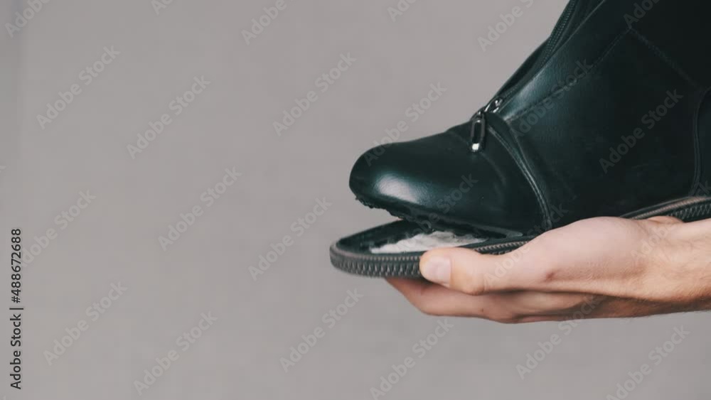 The sole of the shoe talks funny. Male hand holds a boot with a torn ...