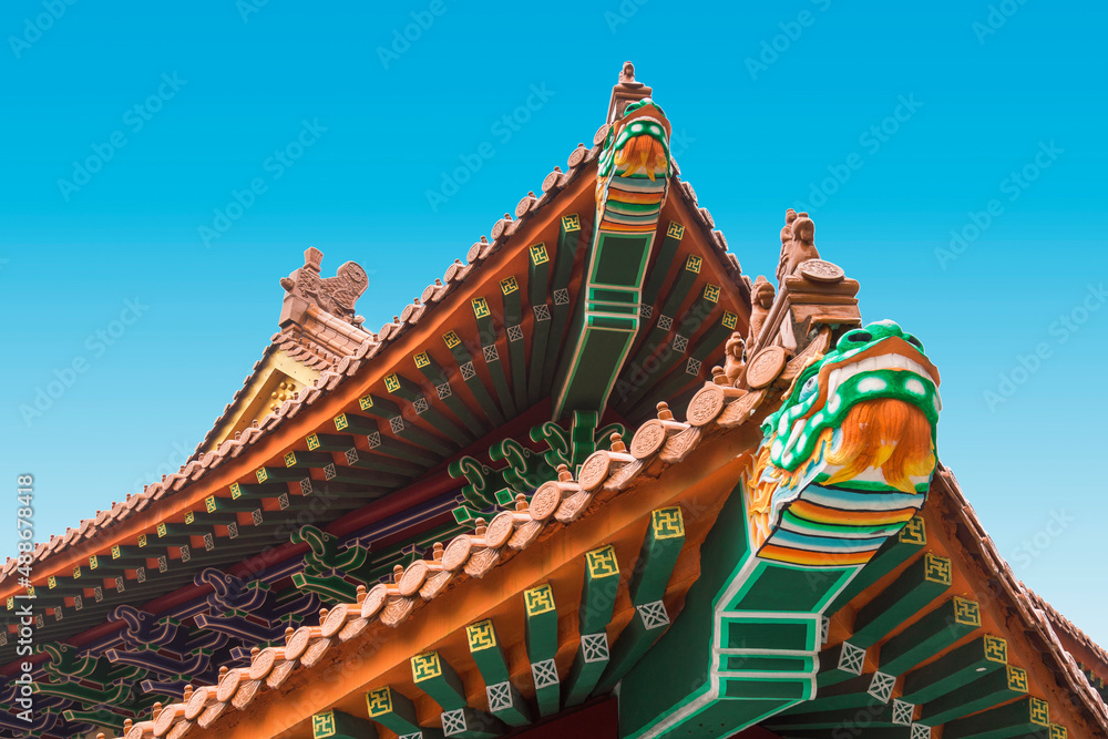 Colorful chinese temple roof detail with a dragon and blue sky ...