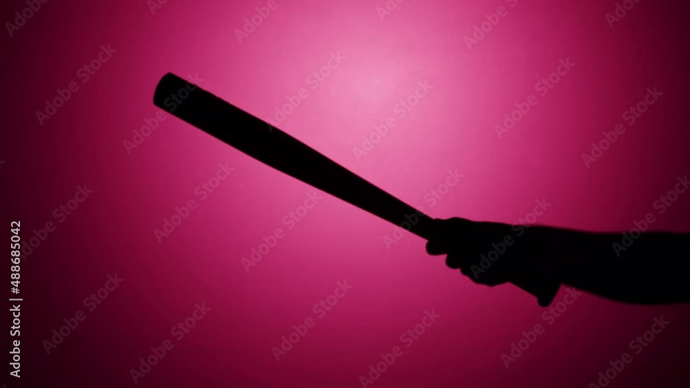 Man holding baseball bat close-up, shadow silhouette of hand with ...