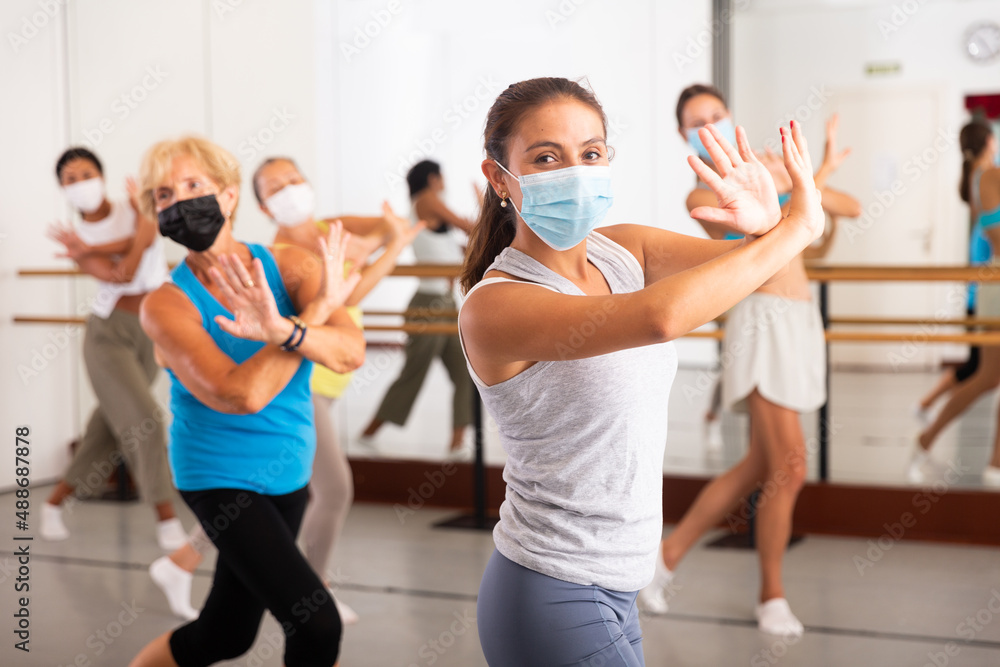 Women of different ages in face masks dancing together during their ...