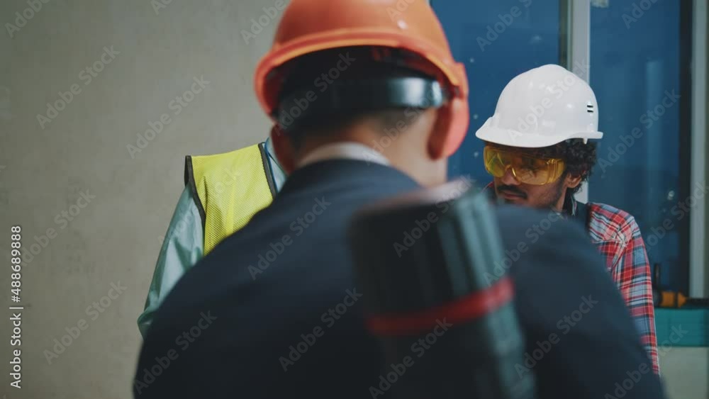 Funny builders engineers with asian architect in hardhats and uniforms ...