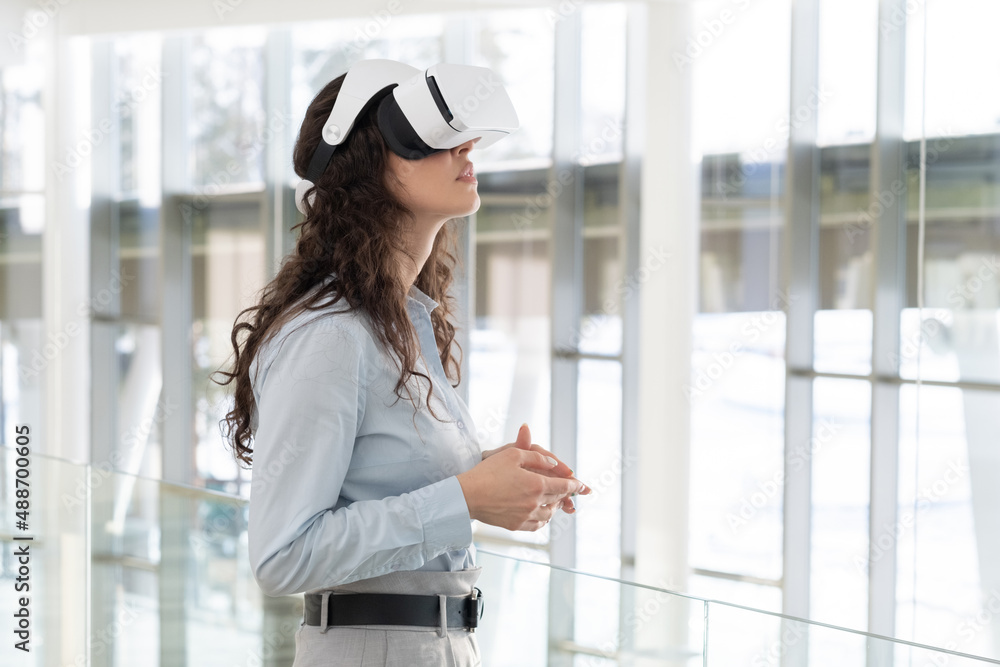 Young contemporary gaming developer in vr headset standing in front of ...