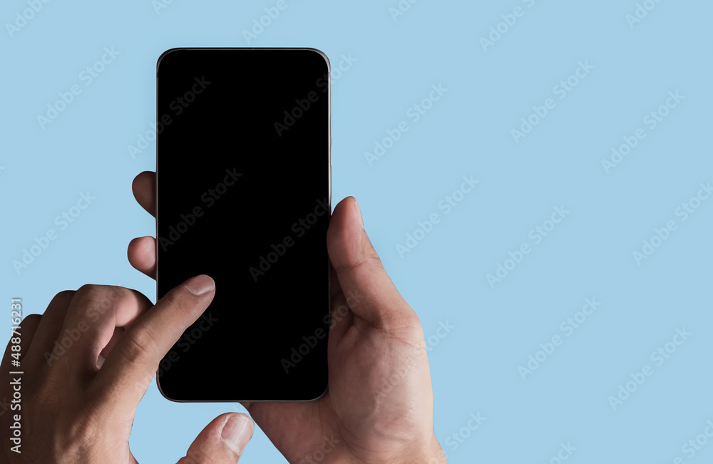 Hand holding blank mobile phone with blank screen in Light Blue ...