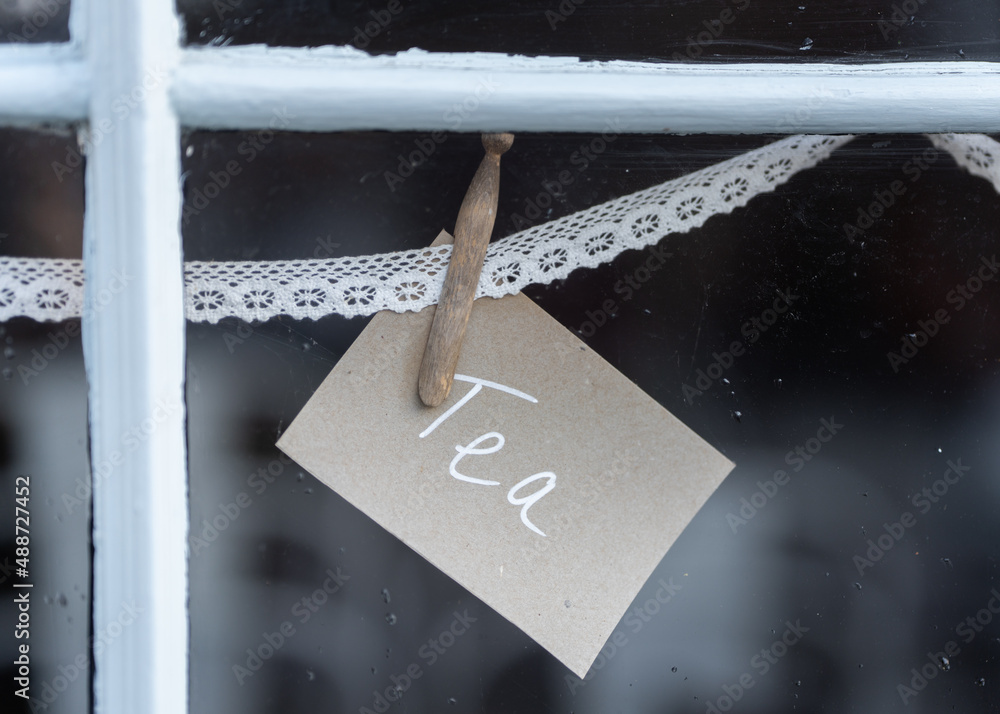 Tea sign pegged to lace in shop window advertising hot drinks to ...