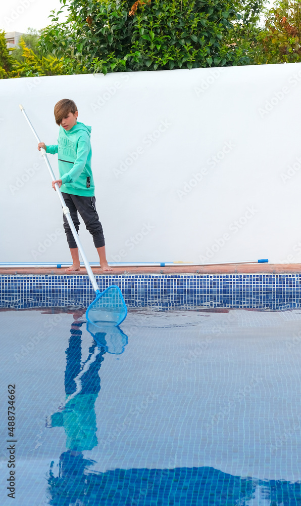 Boy cleaning swimming pool. Teenager after school and house help job ...