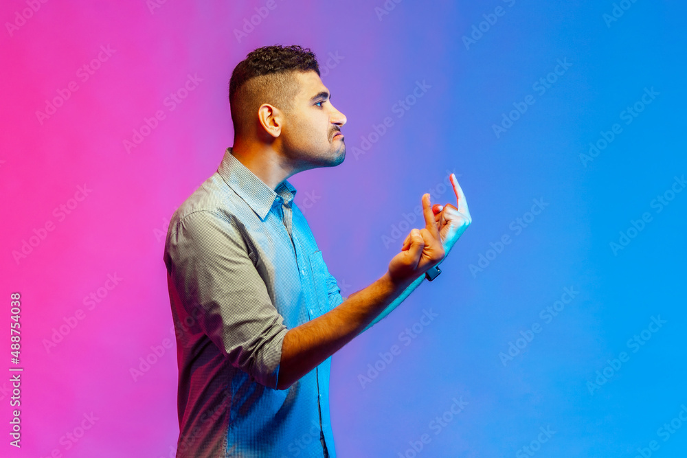 Side view of aggressive man in shirt showing middle finger and asking ...