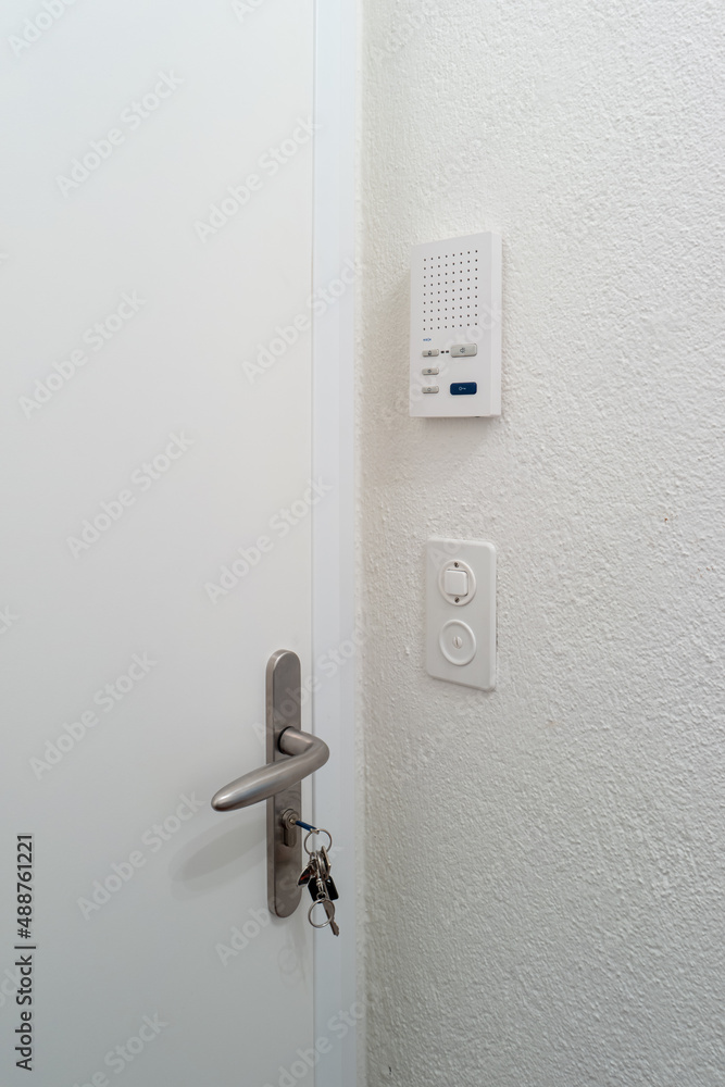 Thick and sturdy white apartment door with keys in the door lock ...