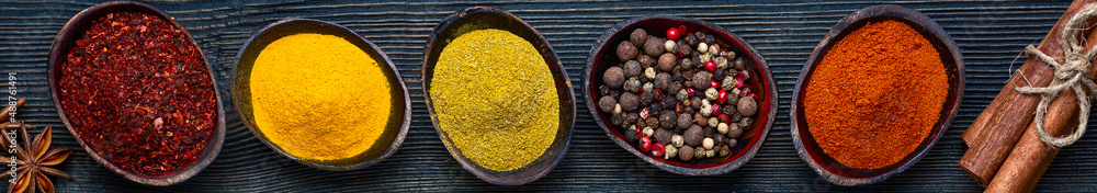 Wooden table of colorful spices. Dark.background. Stock Photo | Adobe Stock