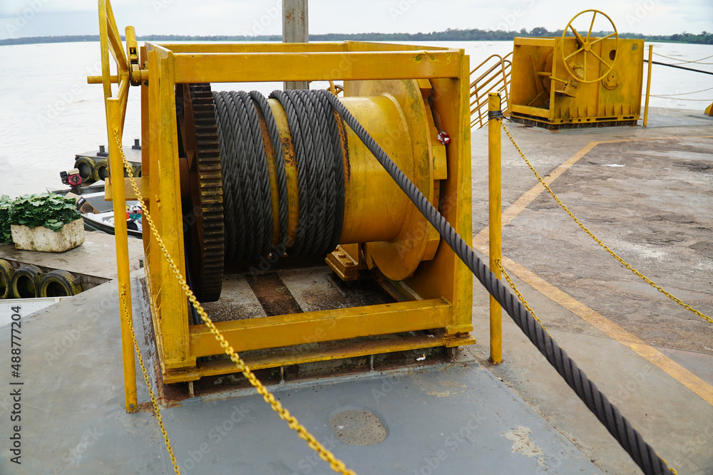 Yellow coastal winch to secure the port pontoon in the small river port ...