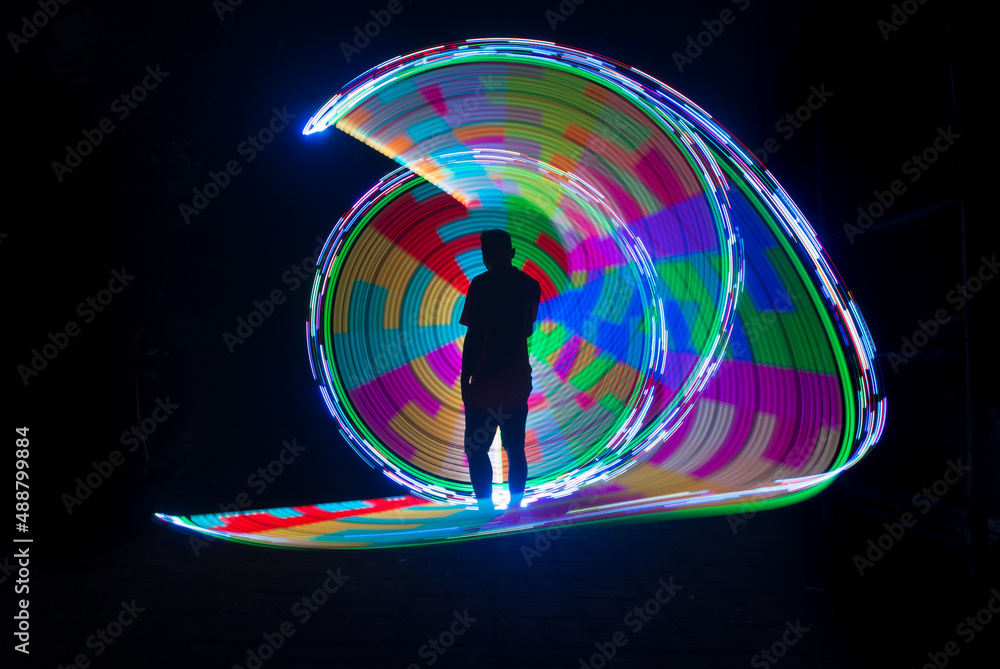 One person standing alone against beautiful color circle LED light ...