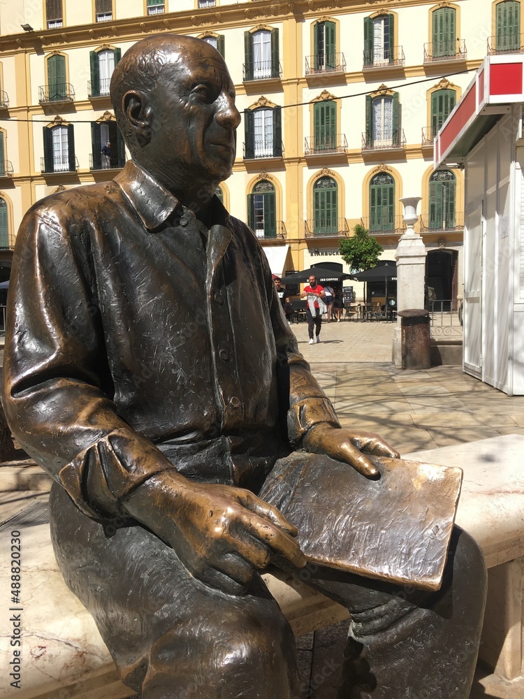 Statue sculpture of artist Pablo Picasso cast in bronze sitting on a ...
