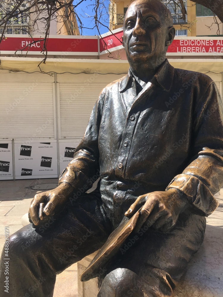 Statue sculpture of artist Pablo Picasso cast in bronze sitting on a ...