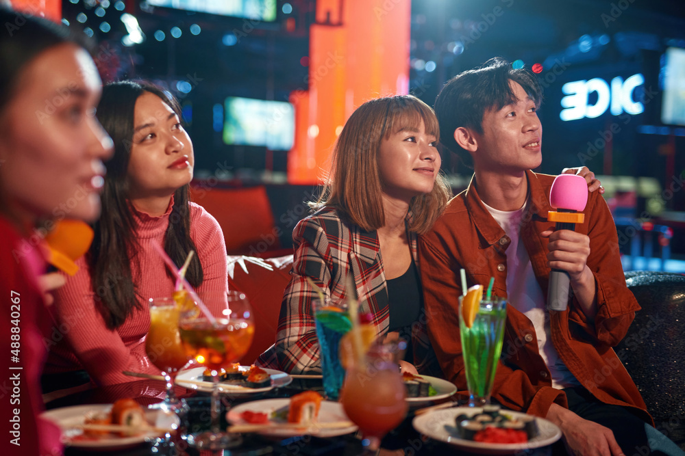 Group of asian guys and girls singing songs at karaoke club Stock Photo ...