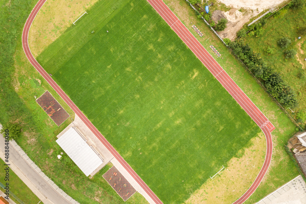 Aerial view of sports stadium with red running tracks and green grass ...