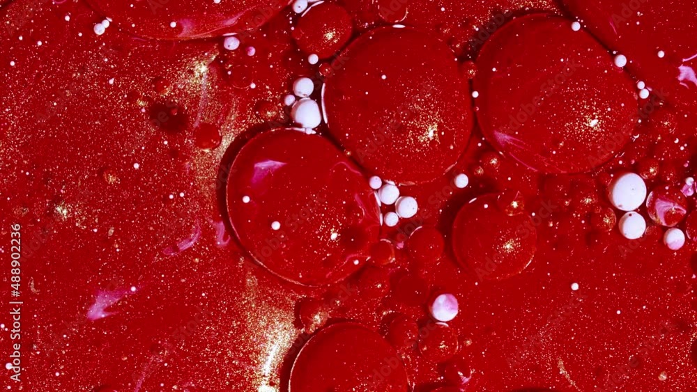 Abstract of red pearl bubbles bursts in glitter paint. Inks, white ...