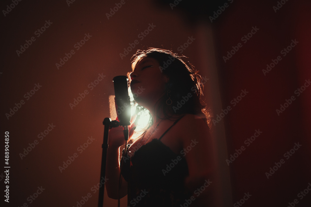 silueta de Joven cantante apasionada a contraluz Stock Photo | Adobe Stock