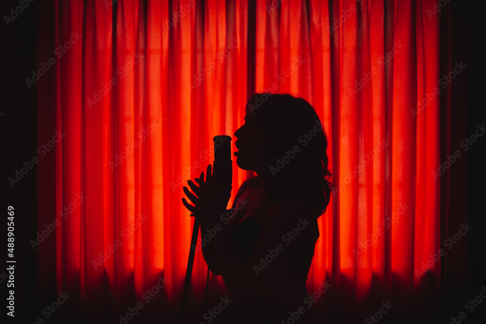 Silueta de joven cantante con fondo rojo foto de Stock | Adobe Stock