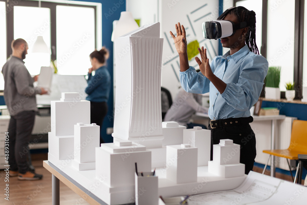 Architect using vr headest to look at white foam scale model of real ...