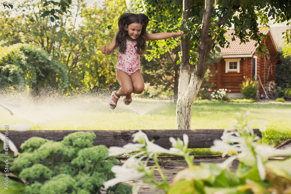 Excited female child playing outside jumping off log looking down in ...